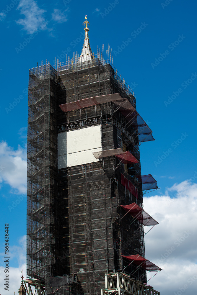 View of Big Ben covered with scaffolding against a blue sky with clouds ...