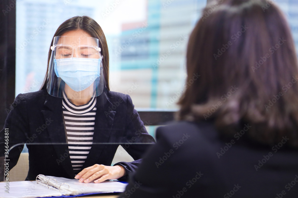 Manager from HR department wearing facial mask is interviewing new ...