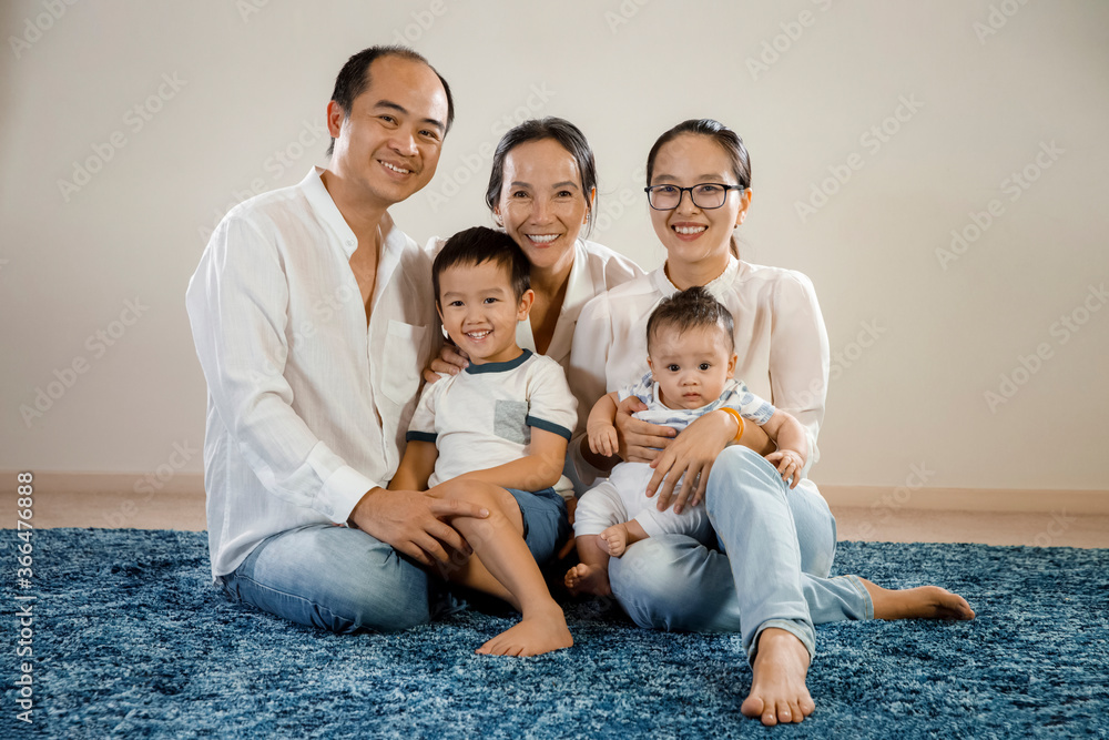 happy asian family hugging together white background sitting on blue ...