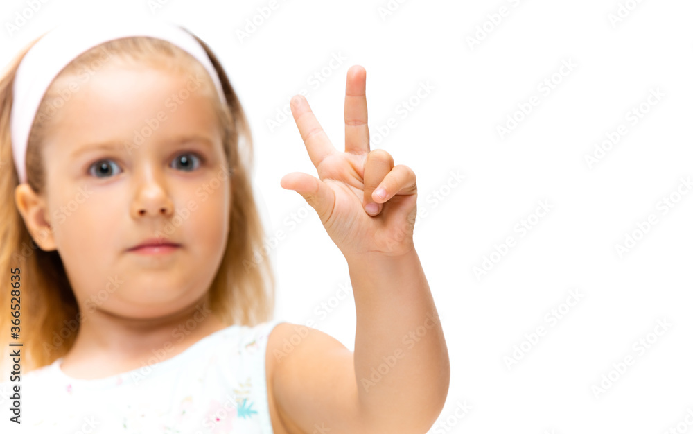 Peace symbol. Little girl gesturing isolated on white studio background ...