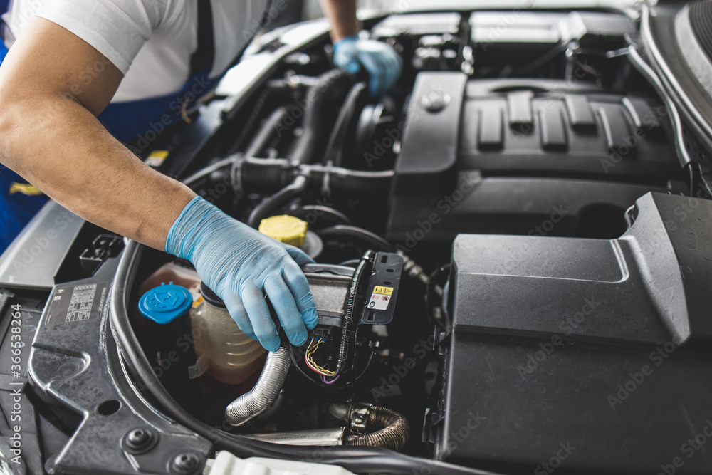 Car service mechanic worker standing in front of car engine open hood ...