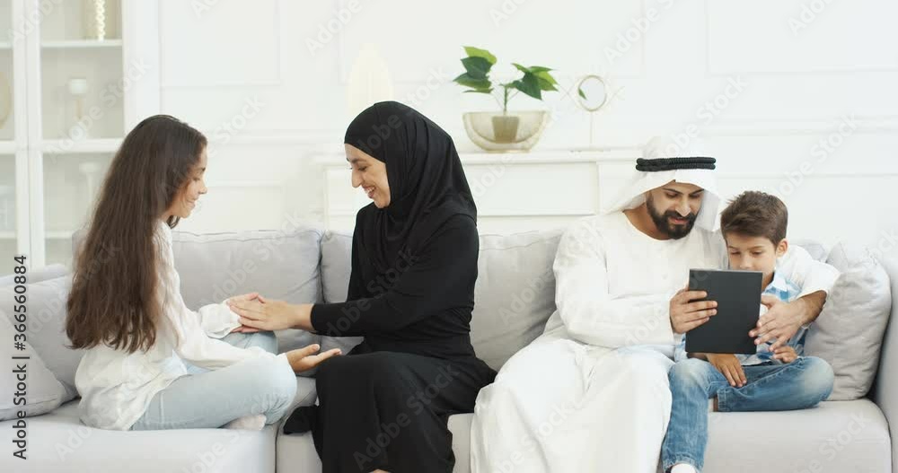 Arab family with kids spending time together in living room. Muslim ...