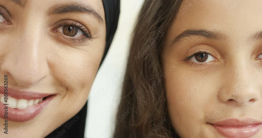Close up of half faces of young beautiful Arab woman in black hijab and ...