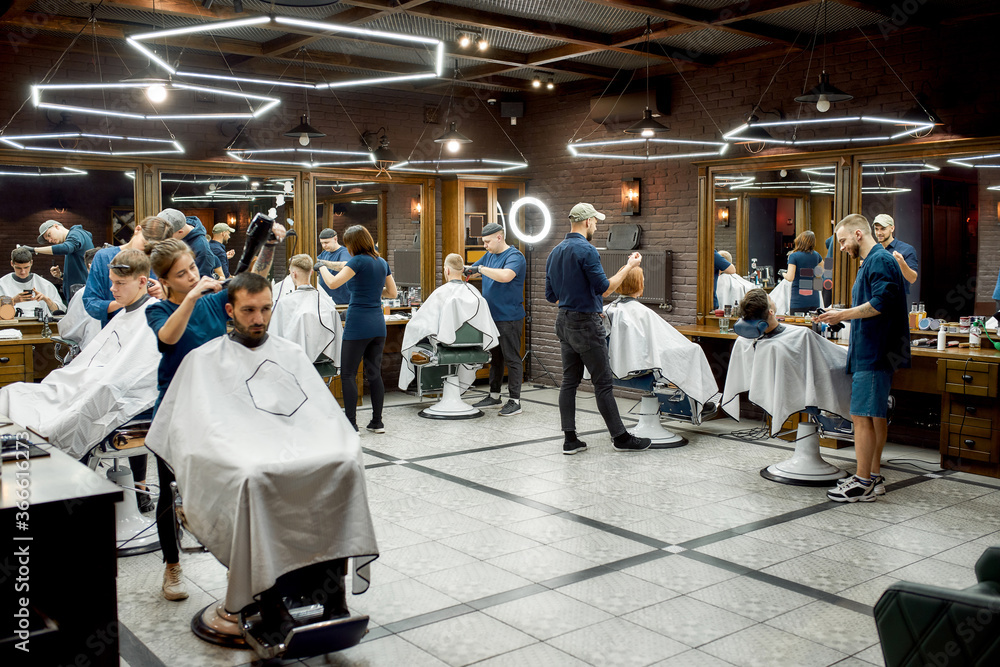 Modern barbershop. Professional barbers serving clients in the modern ...