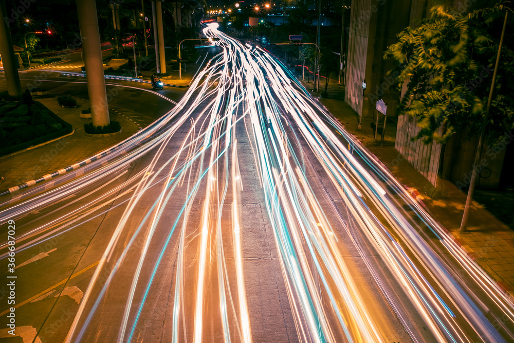 Car lights at evening on the road going to the city. Aerial view of the ...