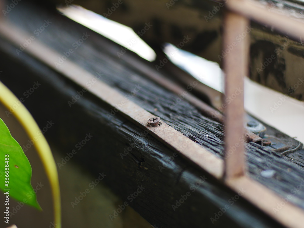 Old and rusty screw metal installed in the lath of the windows ...