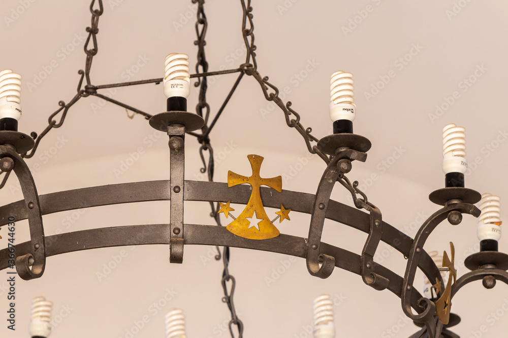 The religious bronze decoration on an iron chandelier hanging in ...