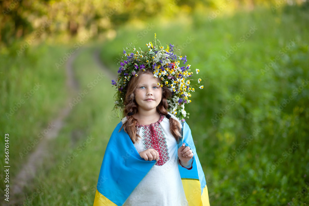Ukrainian child girl in an embroidered shirt and a wreath of ...