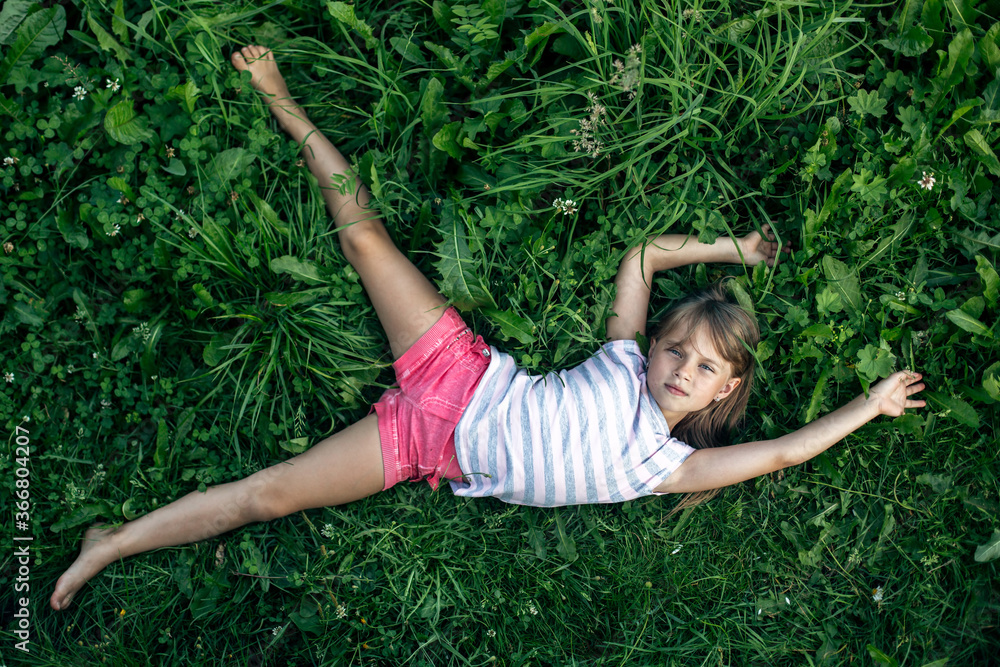 View from top. A little girl lies with her arms outstretched on the ...