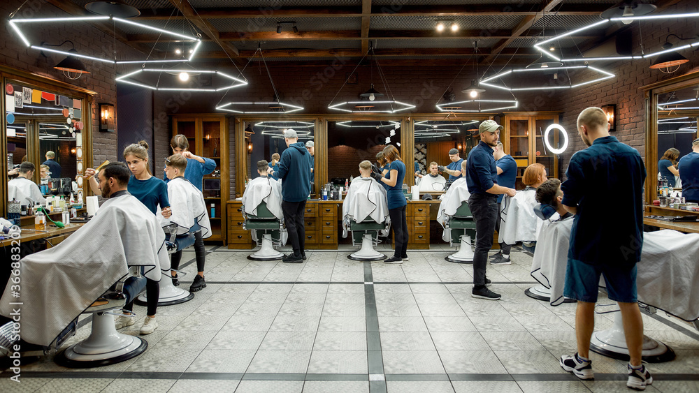 People at barbershop. Professional barbers serving clients in the ...