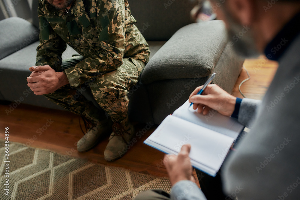 Cropped shot of military man during therapy session with psychologist ...