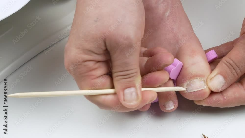 Pedicure with a bamboo stick.Removal of cuticle on the nails.Pink ...