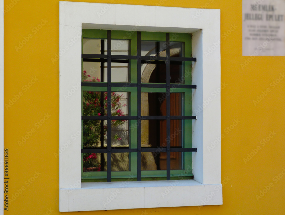 yellow exterior wall detail with white window trim and green wooden ...