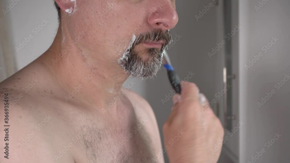A man of middle ages shaving his face with a razor, close-up, 4K Stock ...