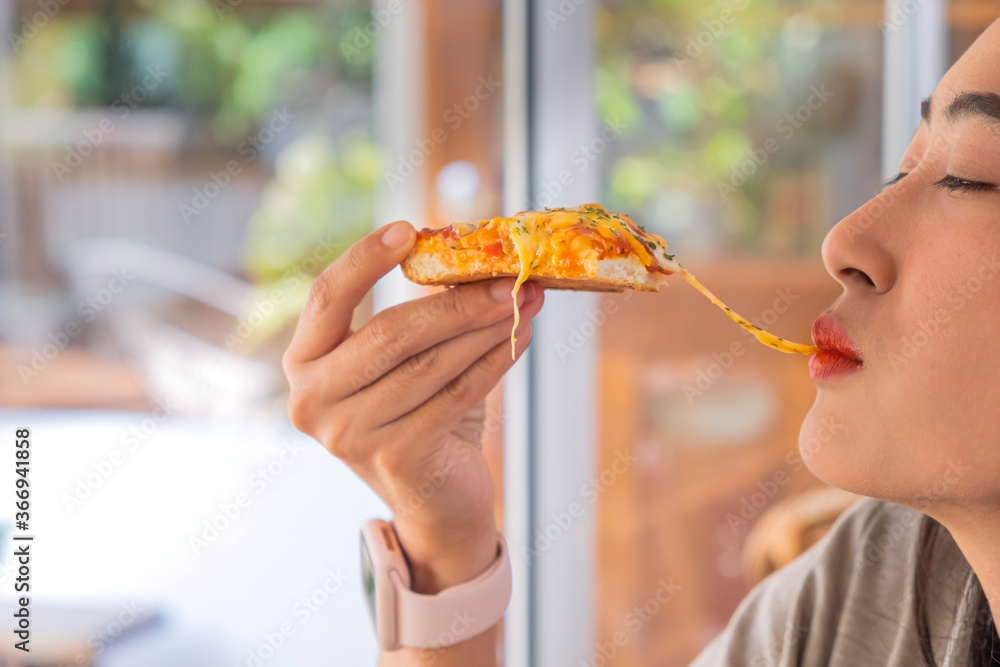 Selective woman eating a pizza, stretching cheese when bitten and ...