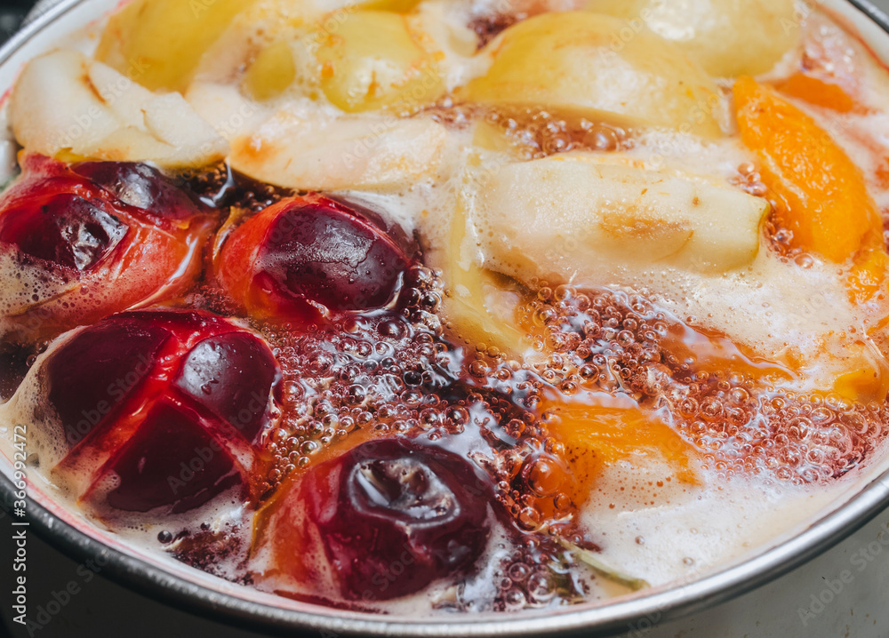 Fruit compote: apricots, plums, apples, cherries are cooked in a metal ...
