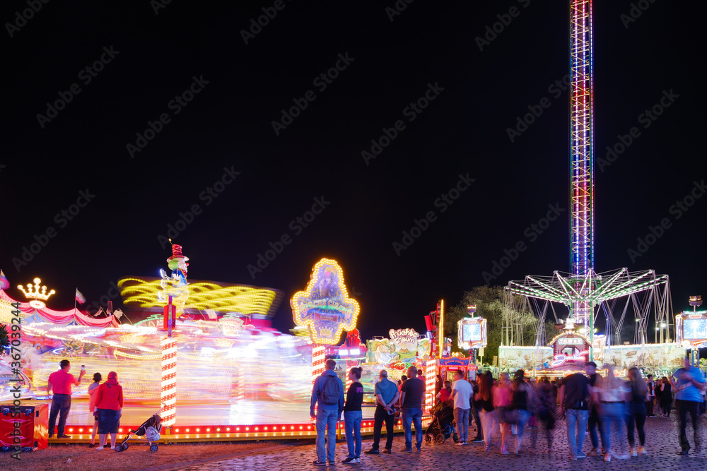 Night atmosphere with spinning and illuminating amusement ride ...