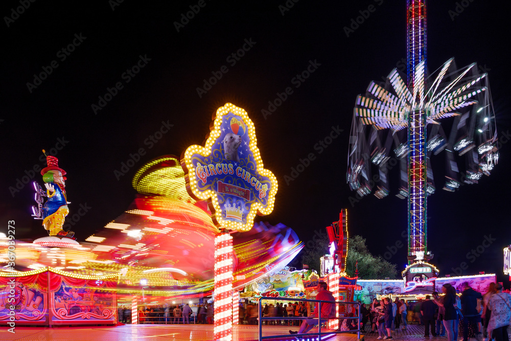 Night atmosphere with spinning and illuminating amusement ride ...