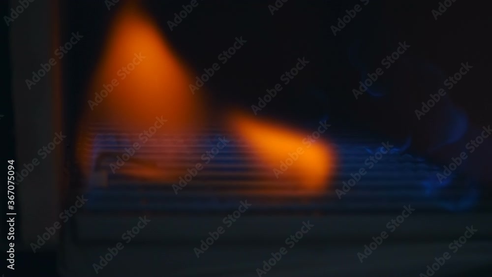 Gas from a spark ignites in a domestic boiler and waves of blue flame ...