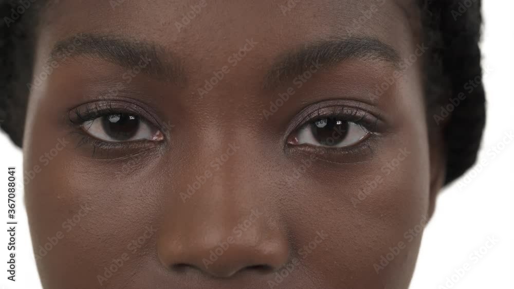 Macro shot of brown eyes. Young African woman raising eyes in slow ...
