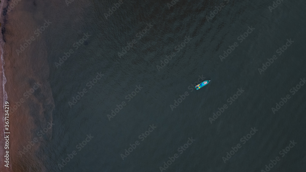 top down aerial view of a floating fisherman's boat above the sea at ...