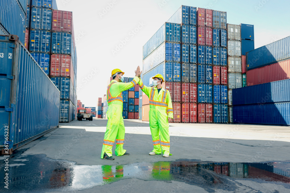 Two workers with protection face mask wearing safety clothing and ...
