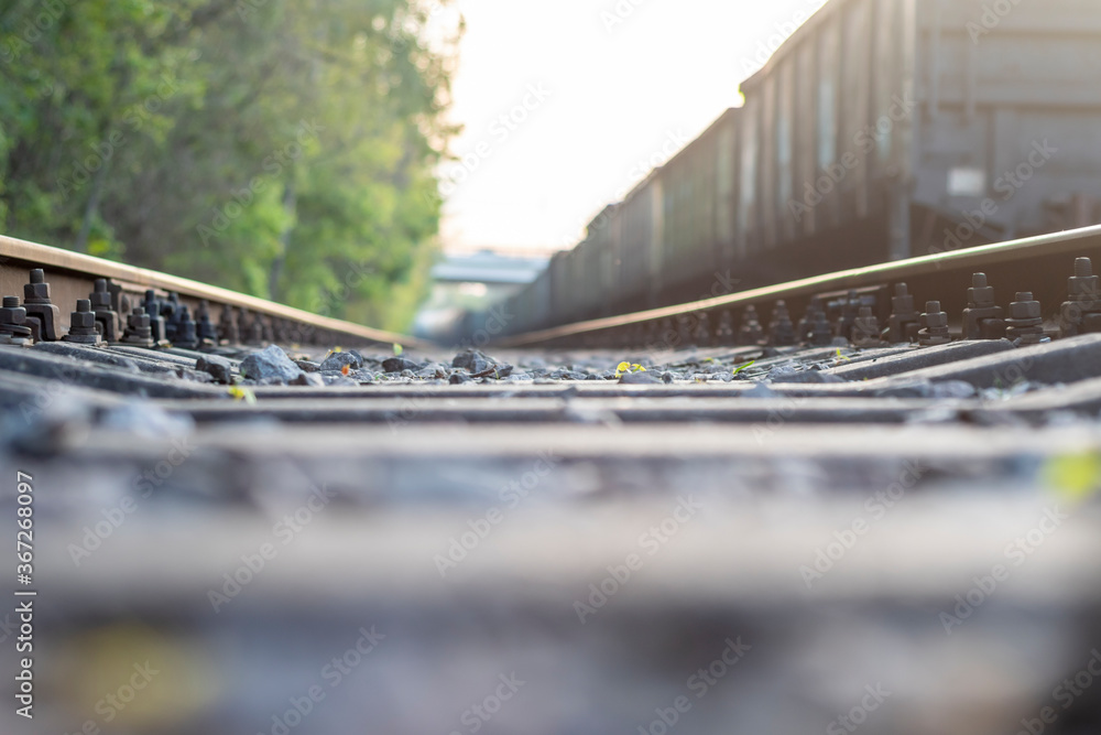 Blurred background with gravel, railroad tracks and standing freight ...