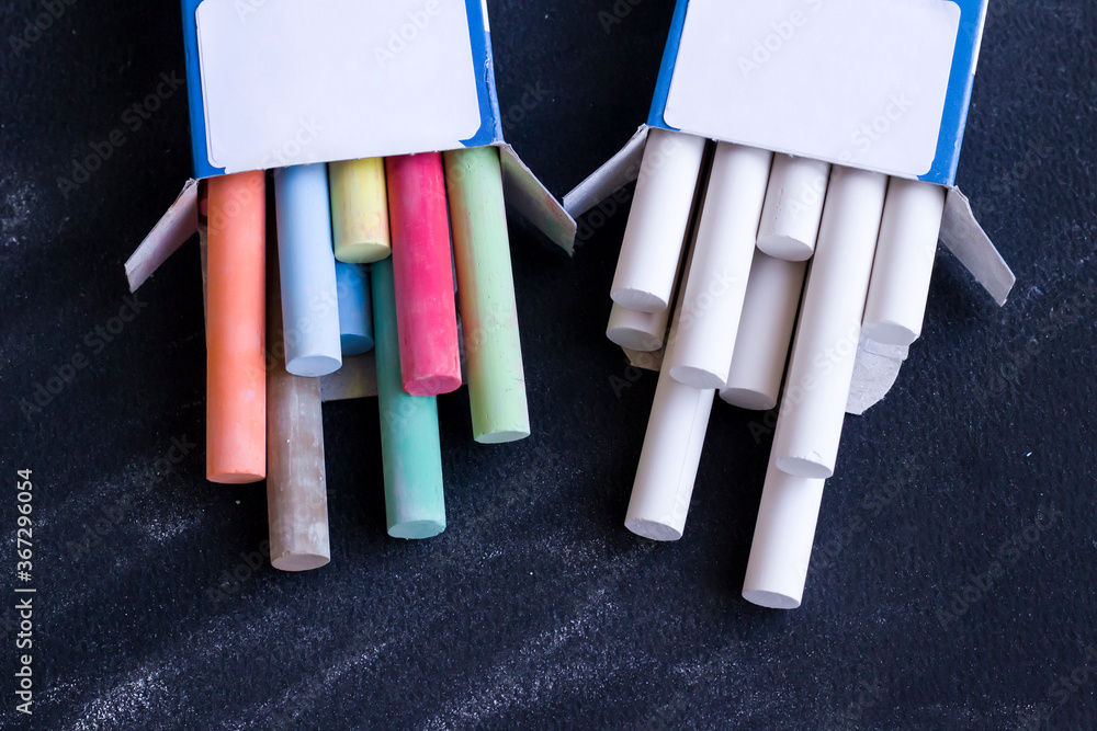 White color and colored chalks in box on the chalk dusty black ...