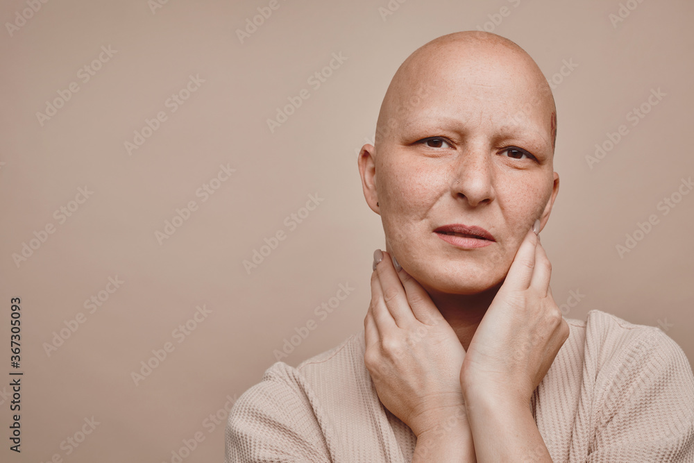 Minimal head and shoulders portrait of bald woman looking at camera ...