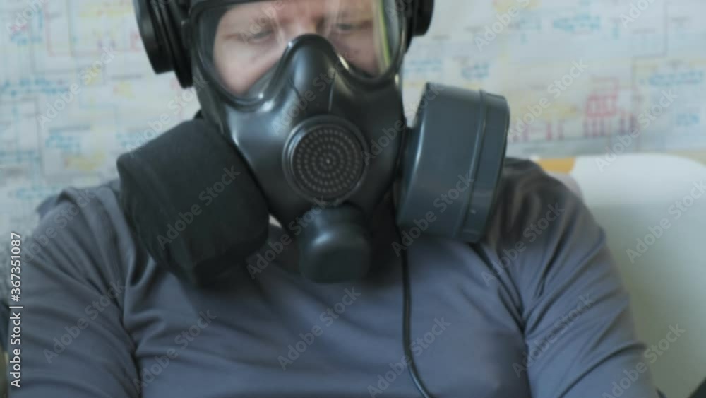 Wideo Stock: funny man in gas mask listens to music in headphones ...