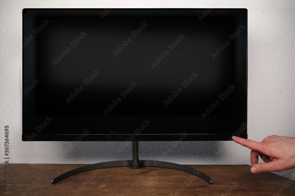 man includes a finger on a button on a 4k computer LCD monitor, a TV ...