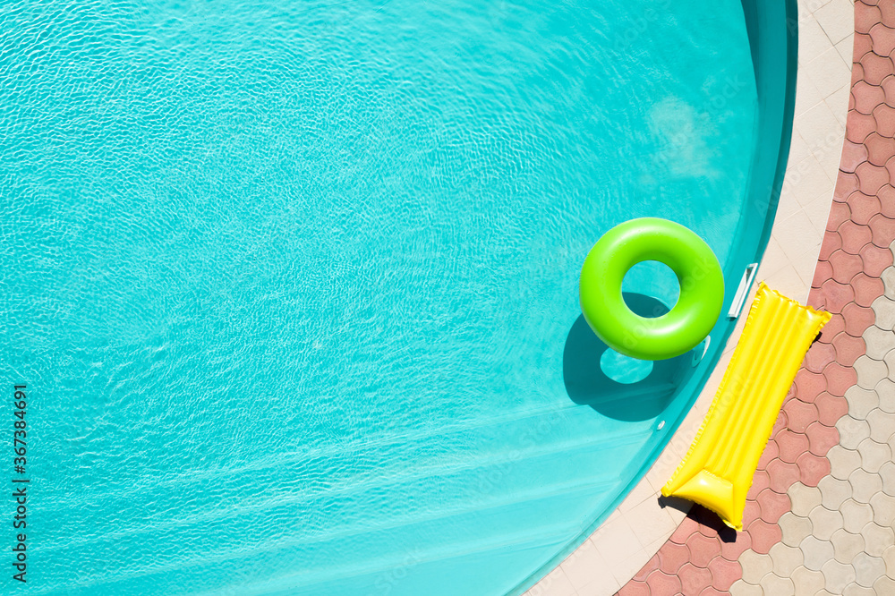 Inflatable ring floating in swimming pool, top view with space for text ...