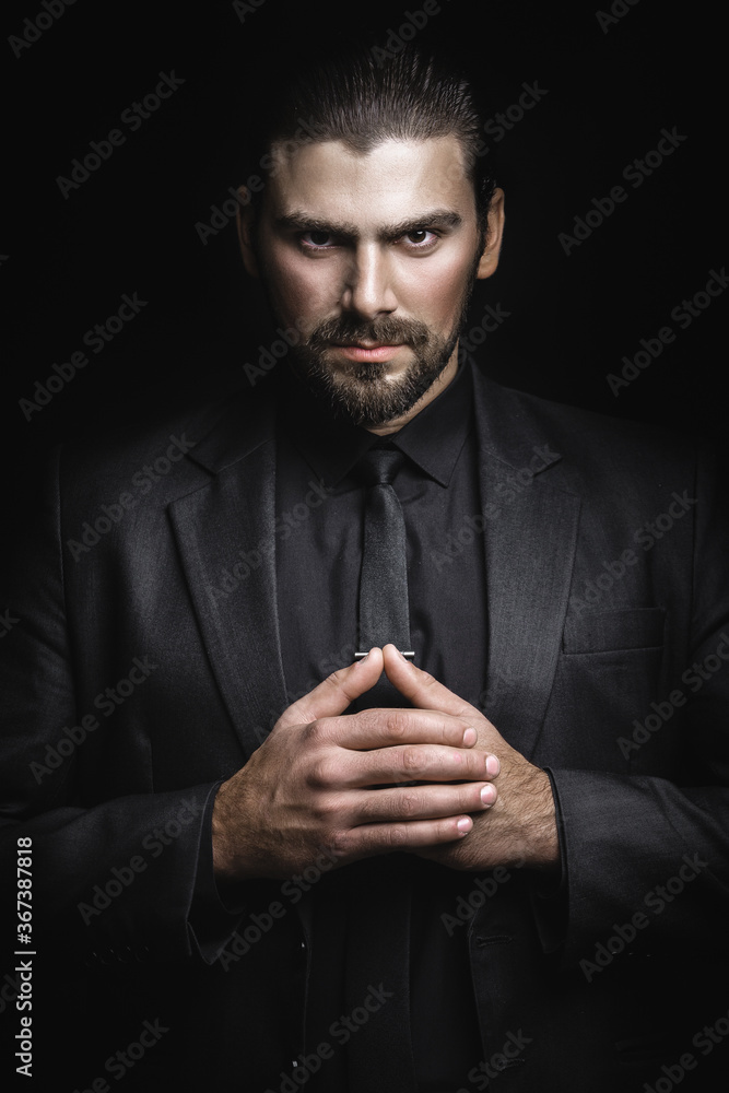 Young white Caucasian man on a black background in a black jacket ...