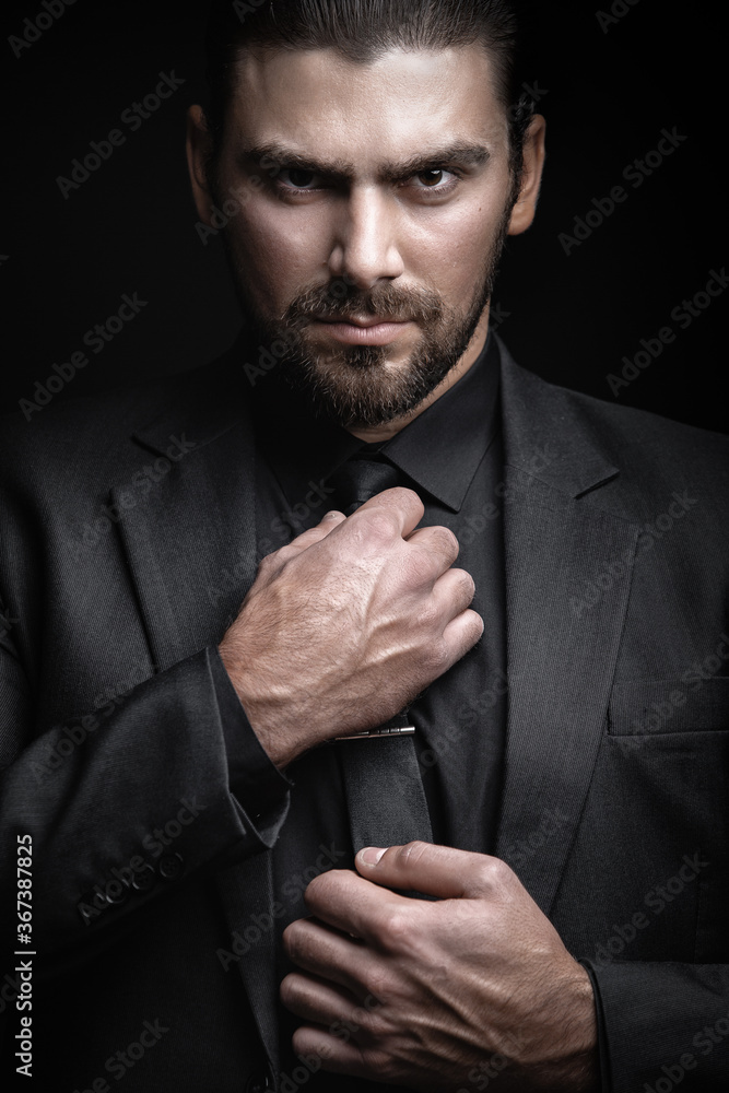 Strict male portrait. The guy in the classic black suit. Half face in ...