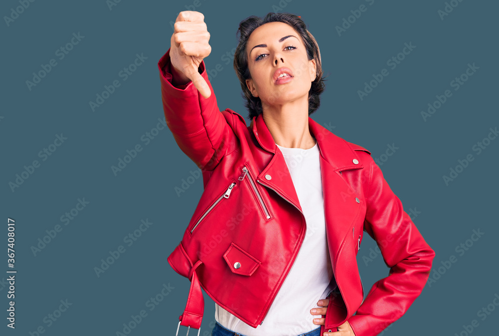 Young beautiful woman wearing red leather jacket looking unhappy and ...