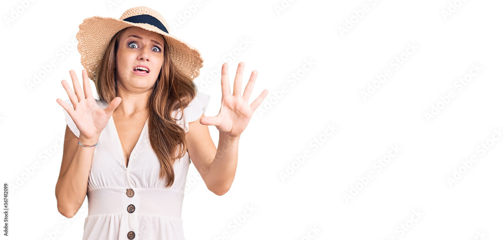 Young beautiful blonde woman wearing summer dress and hat afraid and ...