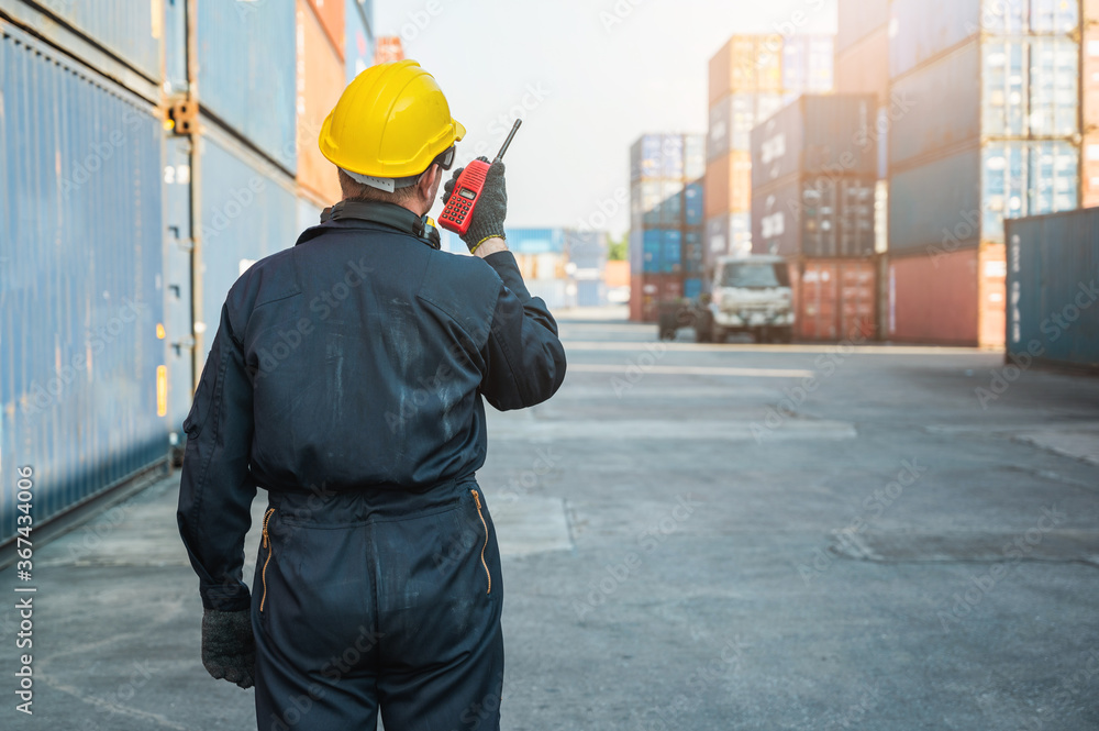 Foreman worker working checking at Container cargo harbor holding radio ...