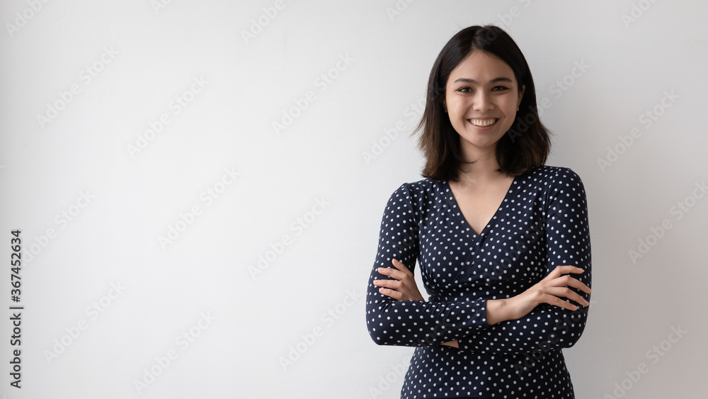 Portrait of happy young Asian woman stand pose isolated on grey studio ...