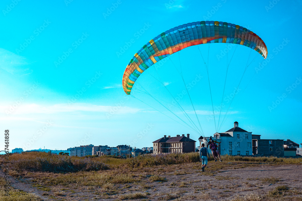 Doubles paragliding landing on the ground. Close-up landing of a multi ...
