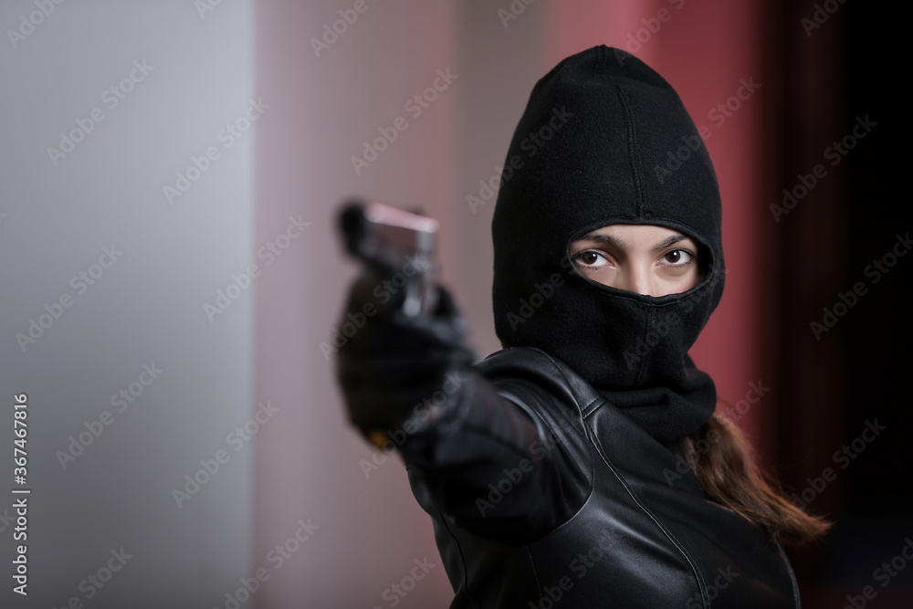 House robbery by woman in a black jacket and black mask holding black ...
