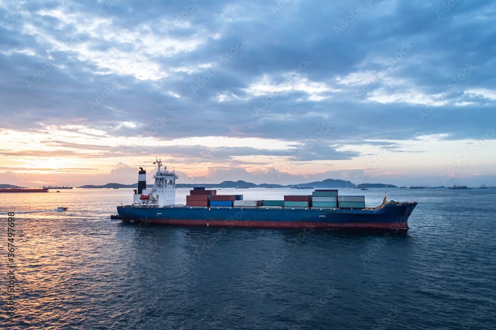Container ship departs port harbor with dramatic background. Container ...