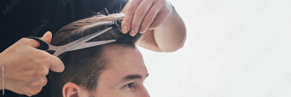 man with a beard cuts and cares for the hair himself in a quarantine ...