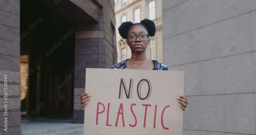 Young african american woman with no plastic poster standing at street ...