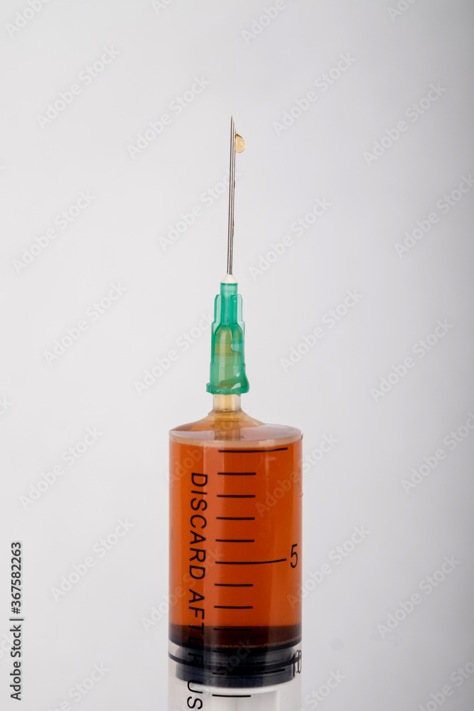 Syringe with needle and liquid drugs in the barrel in a studio with ...