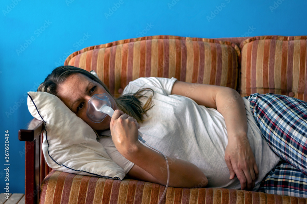 Woman making self-treatment of respiratory tract using inhalation ...