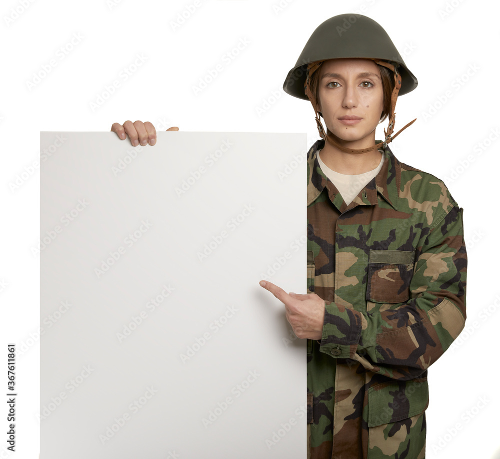 Serious female soldier pointing to a billboard to recruitment or ...