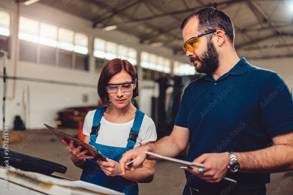 CNC Machine Operator and industrial engineer checking product drawing ...