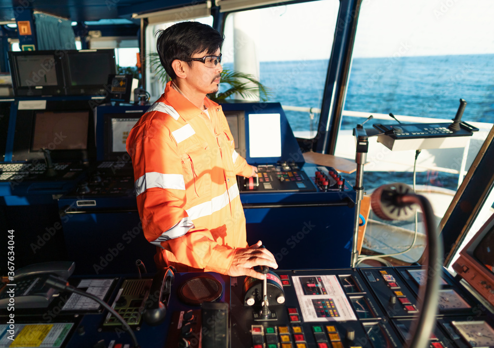 Filipino deck Officer on bridge of vessel or ship wearing coverall ...