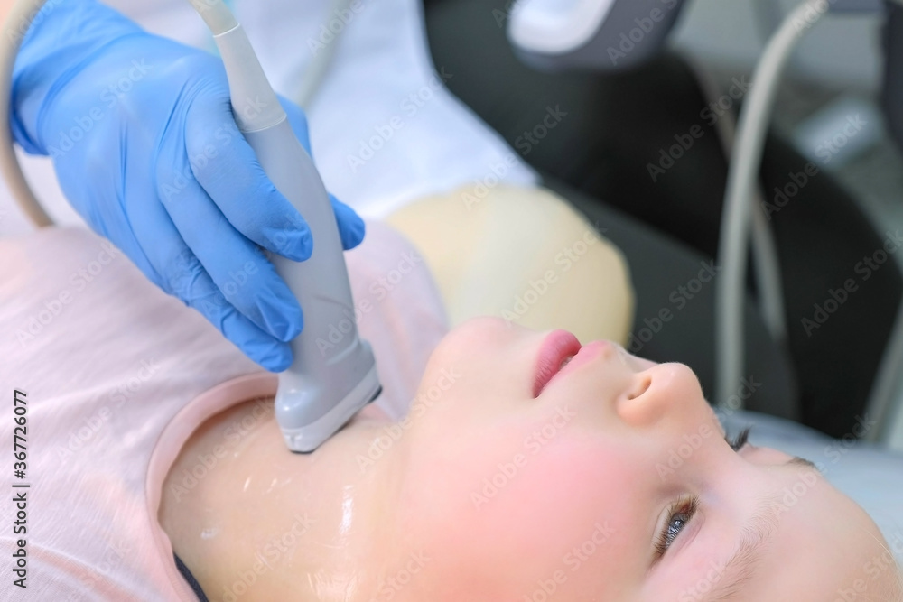 Doctor examining patient child girl thyroid gland using ultrasound ...
