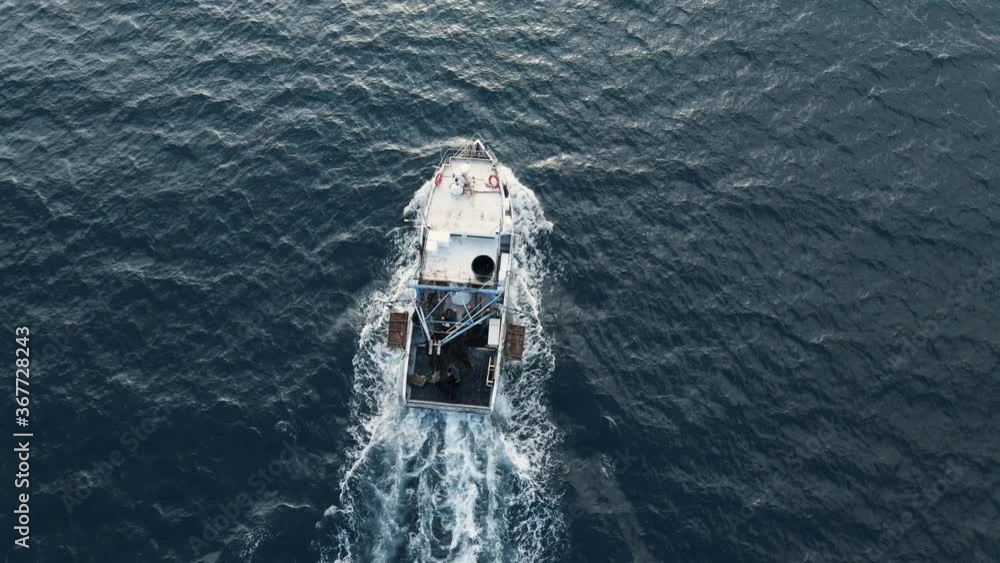 Fishing boat flying drone with large catch fish swirling hungry gulls ...